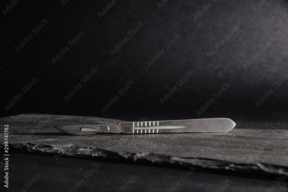 Surgical scalpel on a stone countertop. Medical and pharmaceutical ...