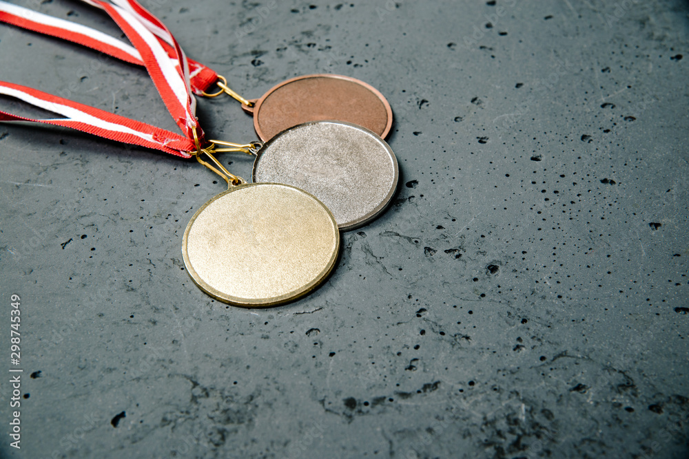 The medals lie on a dark stone background. Gold, silver and bronze ...