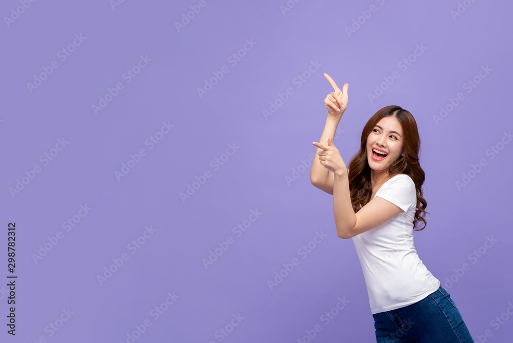 Pretty smiling Asian woman pointing hand to copy space aside Stock ...