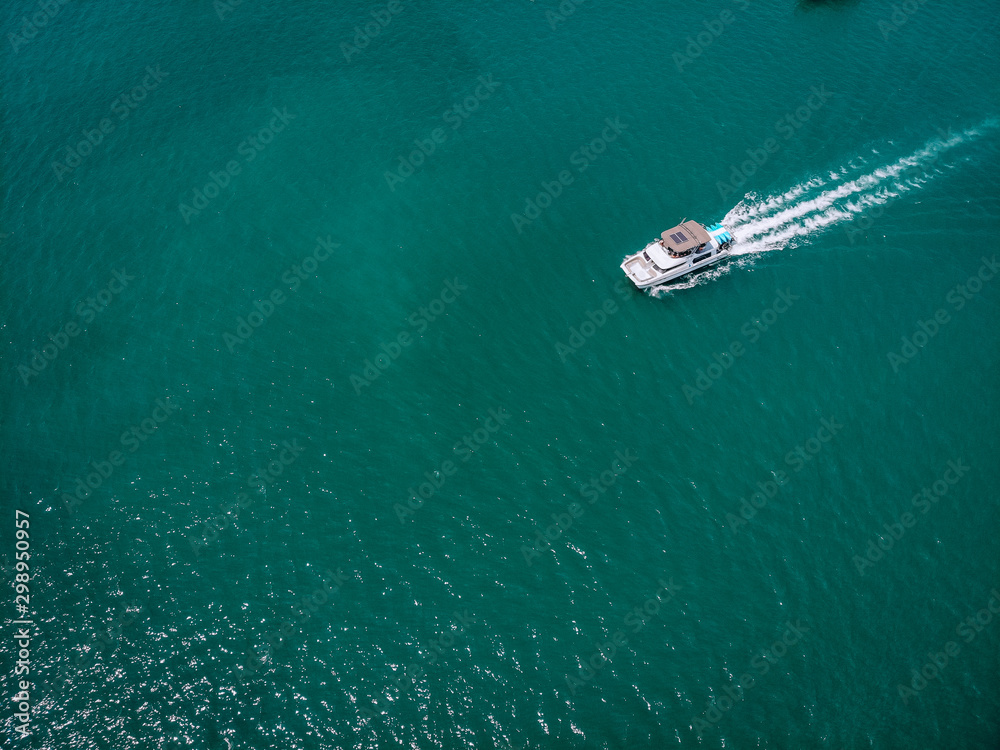 Bird eye view of the white motor boat moving fast, the vessel leaves a ...