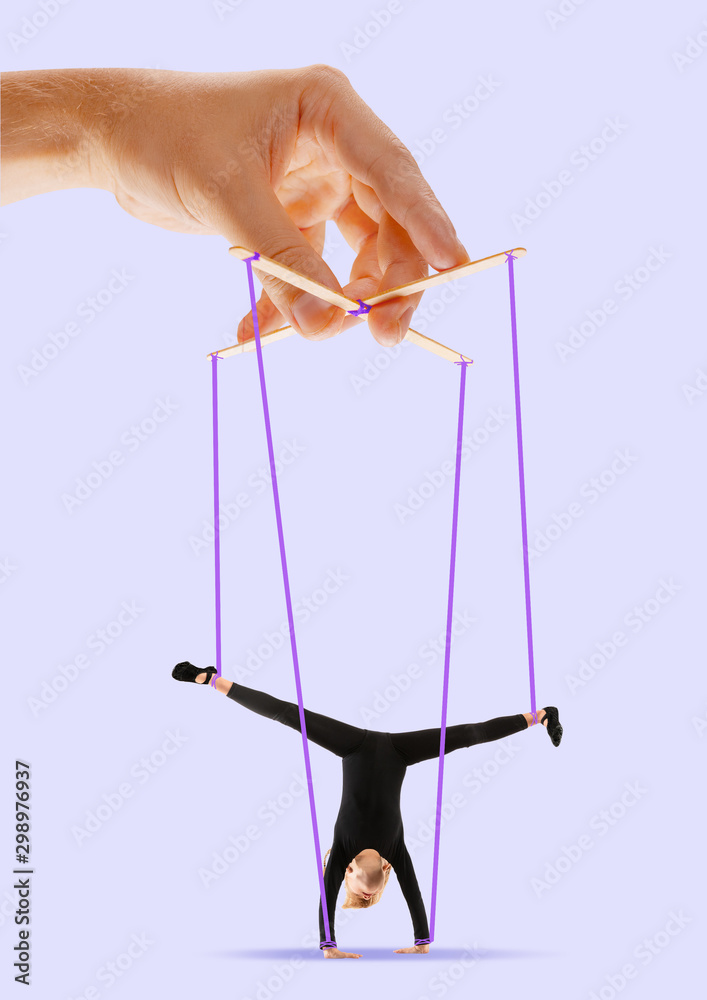 Girl like a puppet in somebodies hands on purple background. Concept of ...