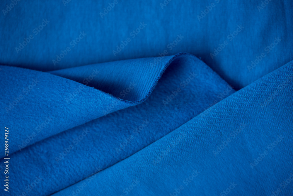 folded piece of bright blue satin fabric isolated on white background ...