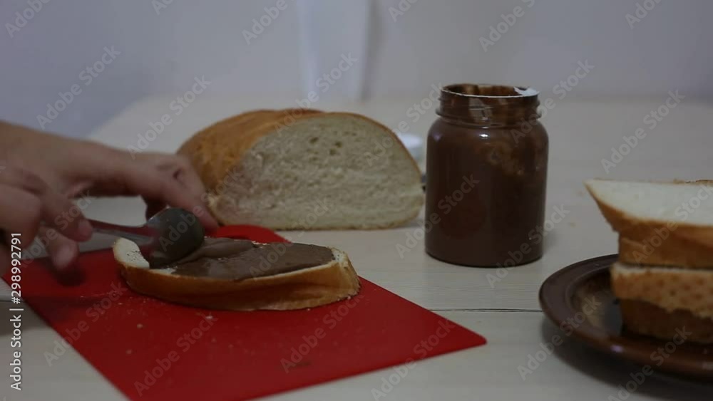 Hands spread chocolate paste on bread. Footage process of slice ...