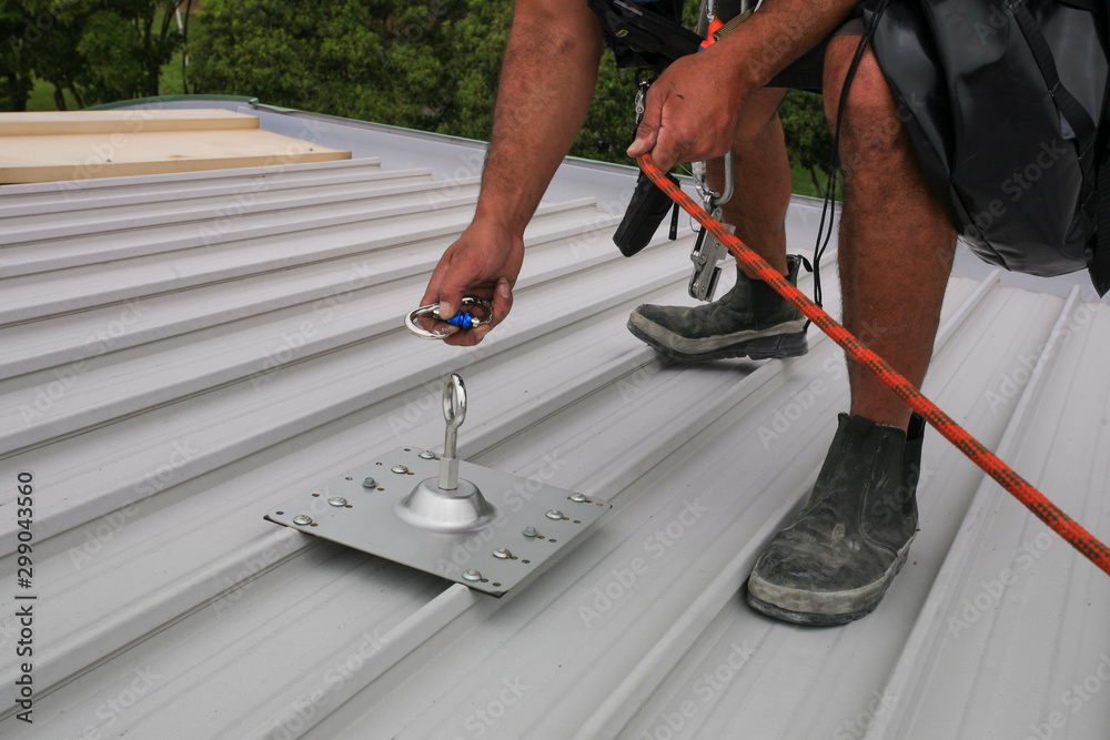 Male hand clipping stainless industrial locking Carabiner into the fall ...