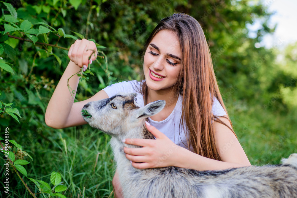 Woman and small goat green grass. Eco farm. Love and care. Animals law ...