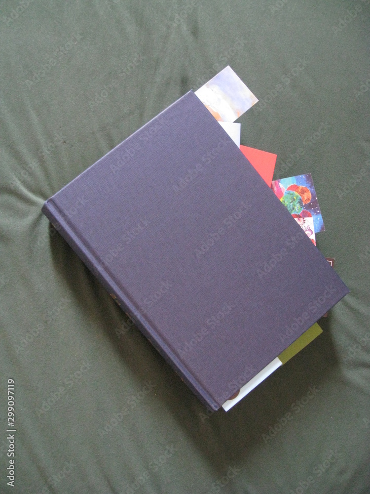 libro azul de tapa dura con varios marcapáginas de colores intercalados ...