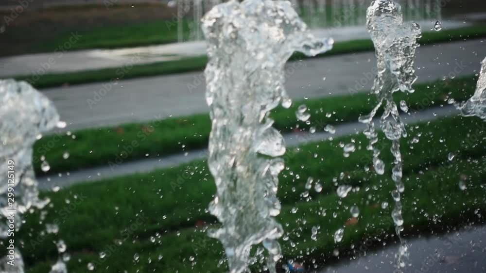 Tracking shot of a row of columns of water at a modern water fountain ...
