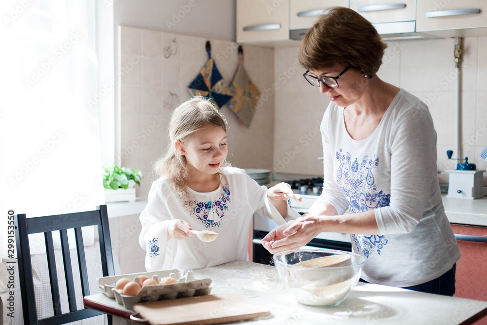 Family is cooking in cozy kitchen at home. Mother and child are making ...