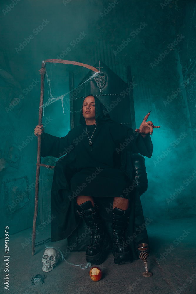 young very angry man with a caucasian face is dressed in a black robe ...