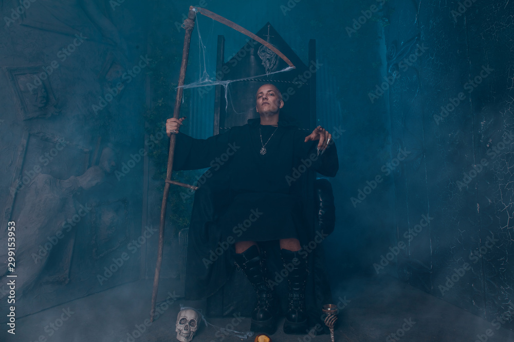 young very angry man with a caucasian face is dressed in a black robe ...