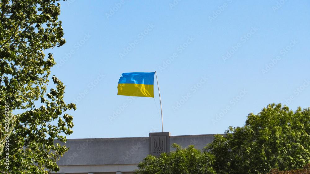 Ukraine flag on sky background. state emblem of Ukraine on the building ...