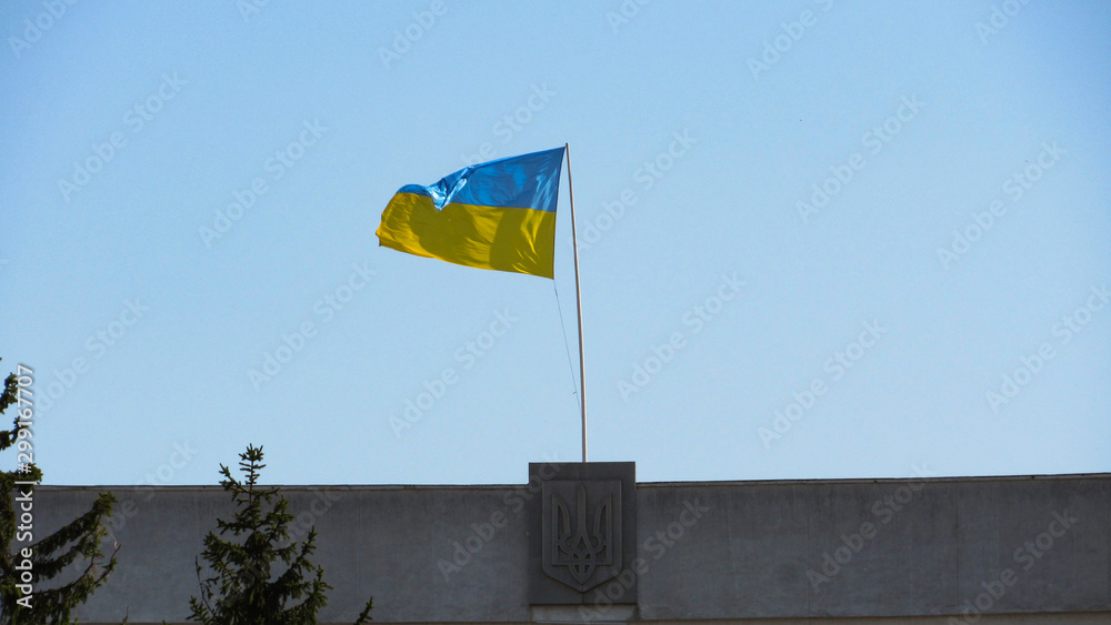 Ukraine flag on sky background. state emblem of Ukraine on the building ...