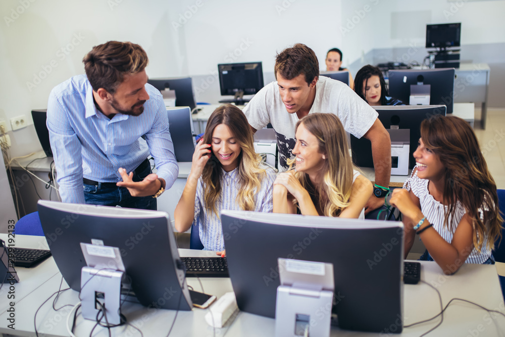 College students sitting in a classroom, using computers during class ...