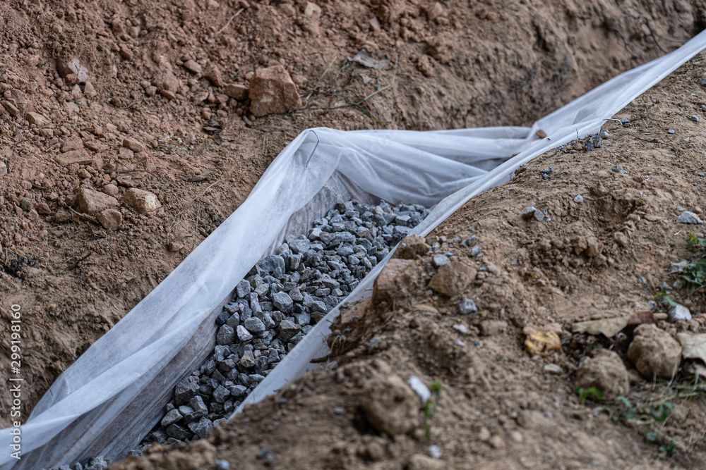 Drainage Rock in a French drain as part of a DIY home repair of ...