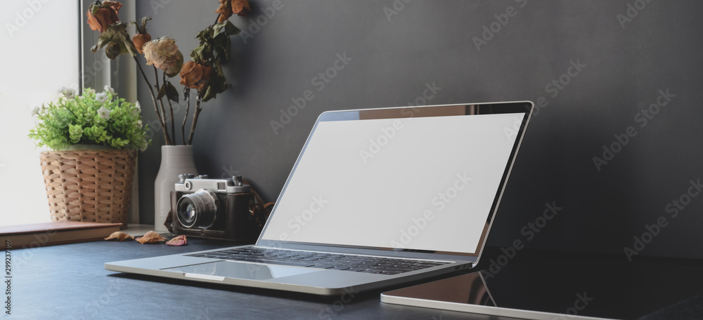 Dark modern workspace with mock up laptop computer and office supplies ...
