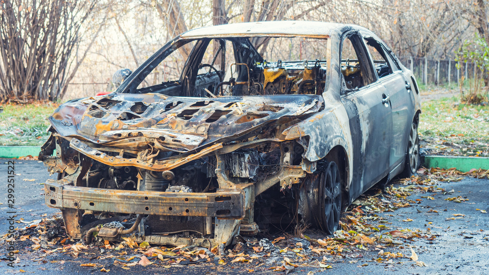 destroyed vehicle after a fire melted is on the street. people burned ...