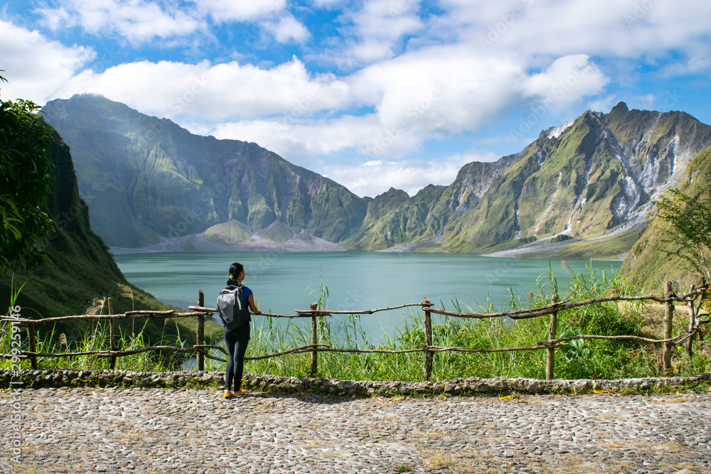 Young Asian girl stands at overlook near crater of Mount Pinatubo ...