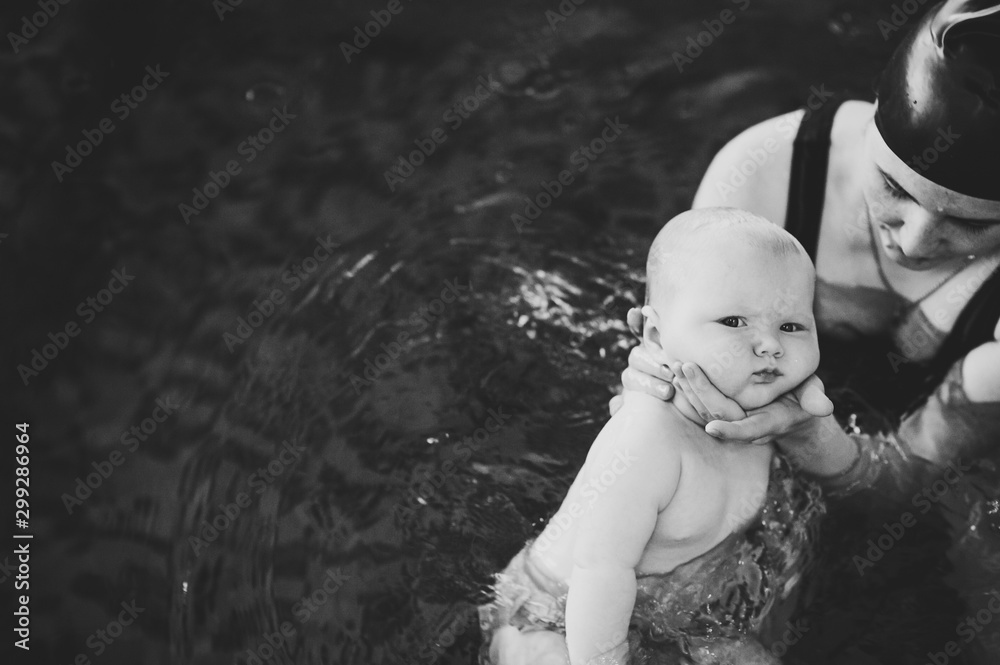 Young mother, happy little girl in pool. Teaches infant child to swim ...