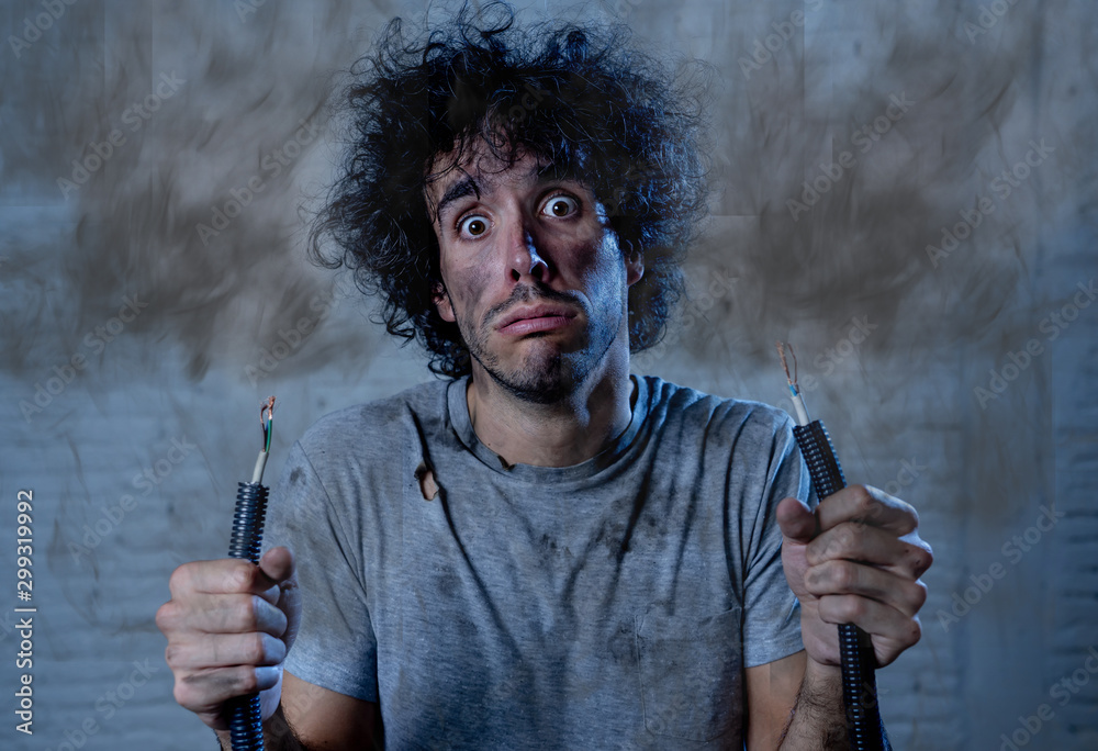 Funny image of man holding electrical cable after getting electric ...