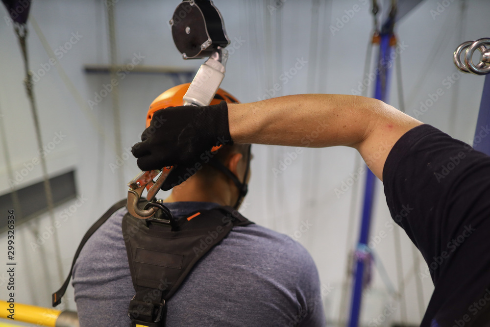 Male hand wearing a safety glove clipping inertia reel connecting into ...