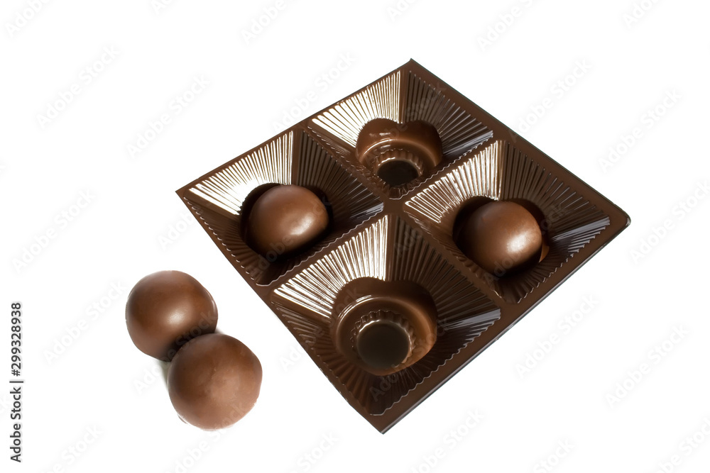 Two round chocolate candies in a plastic square package and two next to ...