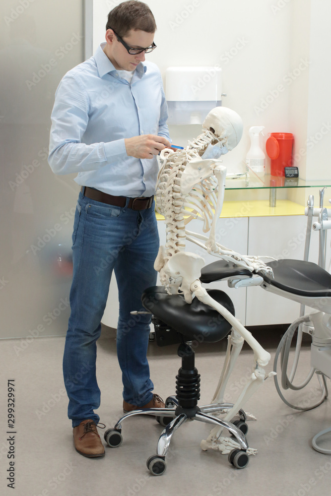 expert pointing at cervical spine of human skeleton model as a dentist ...