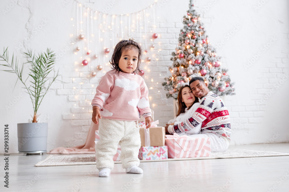 Little restless child climbs on boxes with gifts on the background of ...