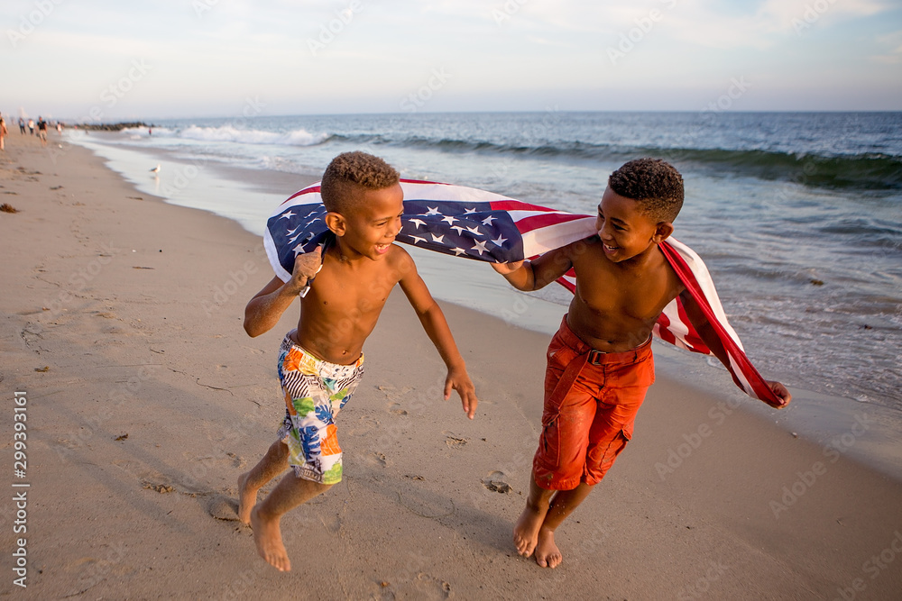 Patriotic fun at the beach boys running with the American flag Stock ...