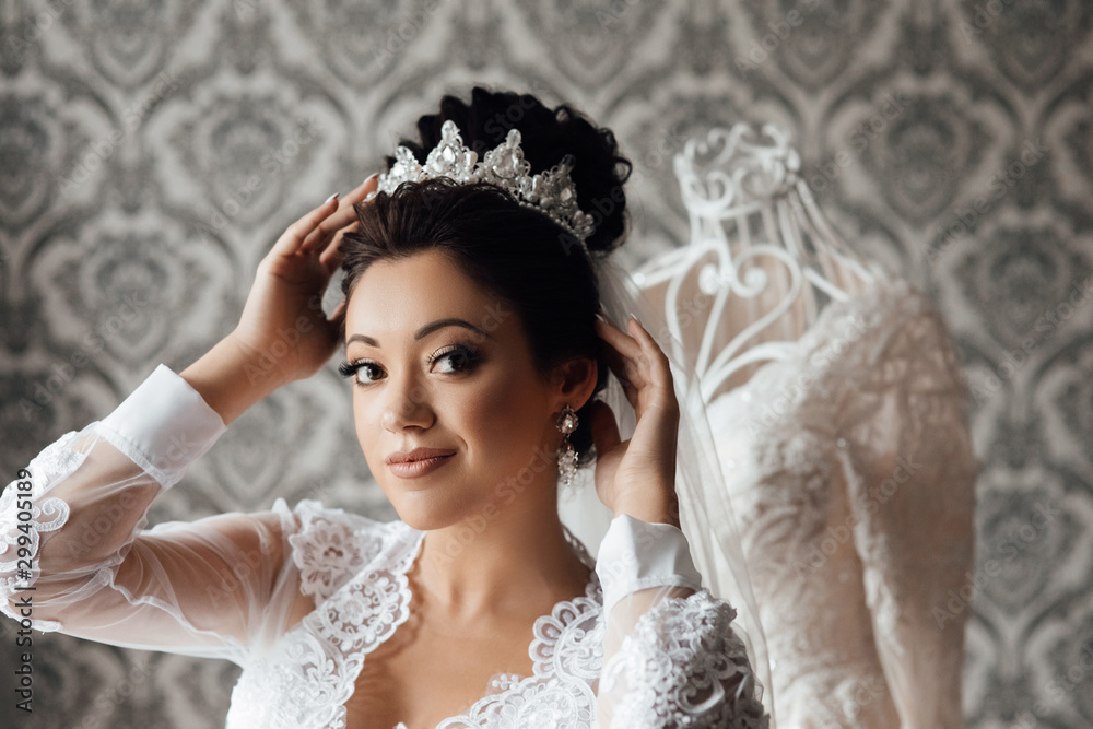 Beautiful happy brunette bride in a stylish robe posing near manequin ...