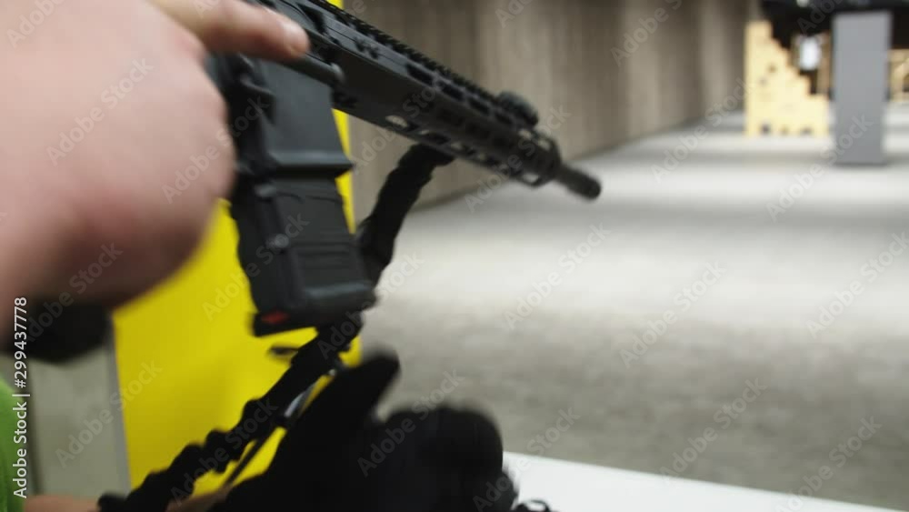 Handheld shot of white male safely inserting a magazine cartridge into ...