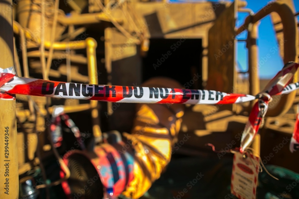 Danger red and white tape barricade exclusion area at confined space ...