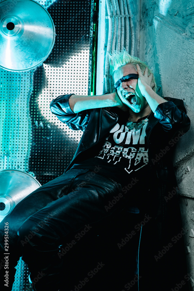 Fashion portrait of the young beautiful alternative man in leather long ...