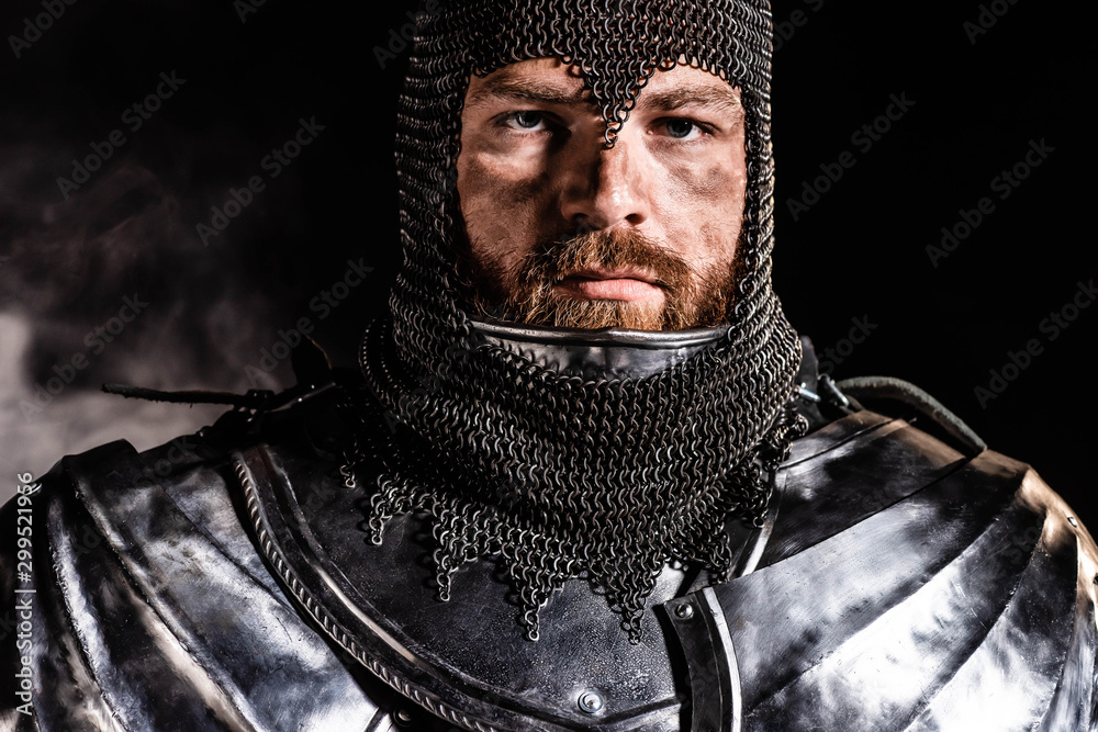 handsome knight in armor looking at camera on black background Stock ...
