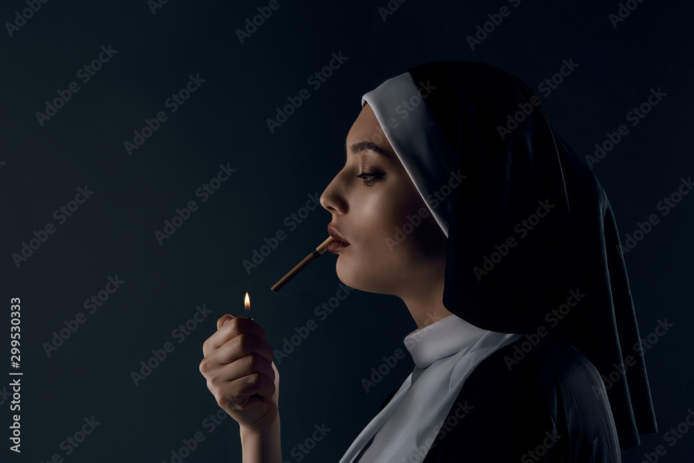 Profile shot of upper nun's body, posing on black background. She ...