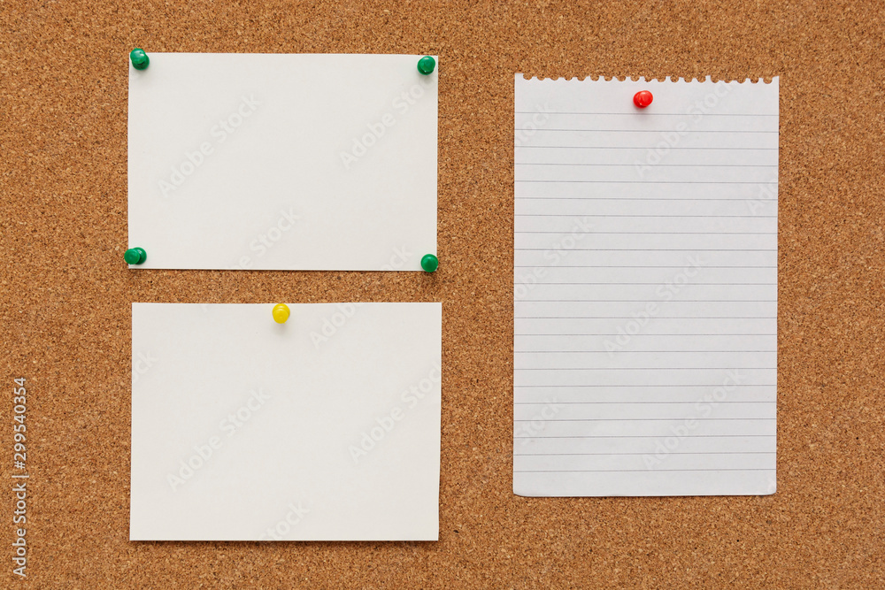 Note paper swith push pins on cork board. Empty paper pages for notes ...