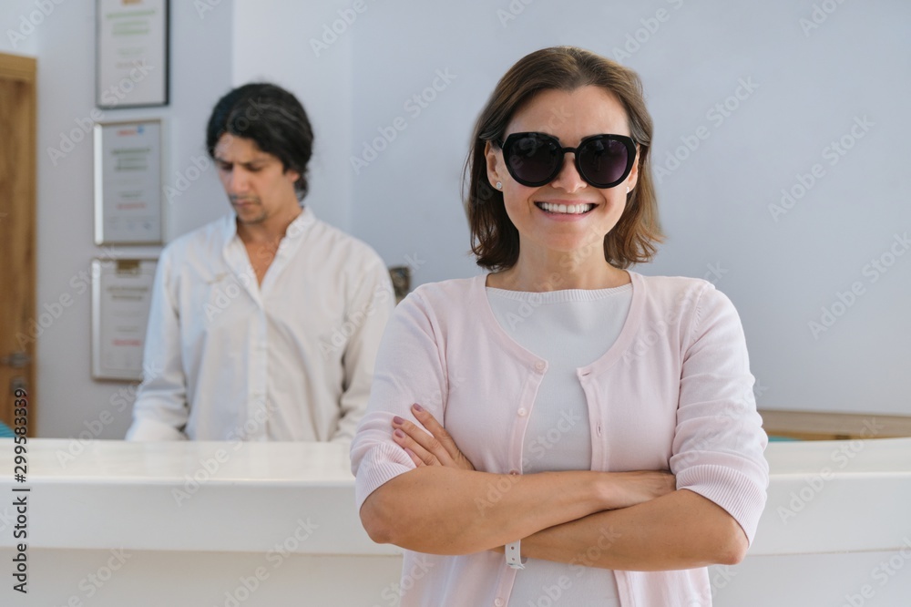 Smiling happy woman guest in lobby interior of resort spa hotel, male ...