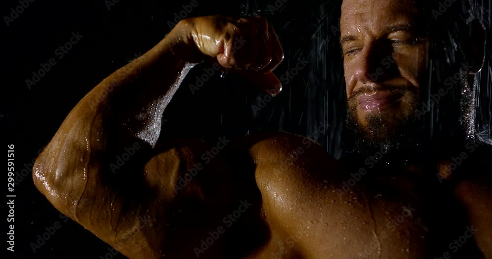 close-up portrait of a brutal bodybuilder in the dark in the rain ...