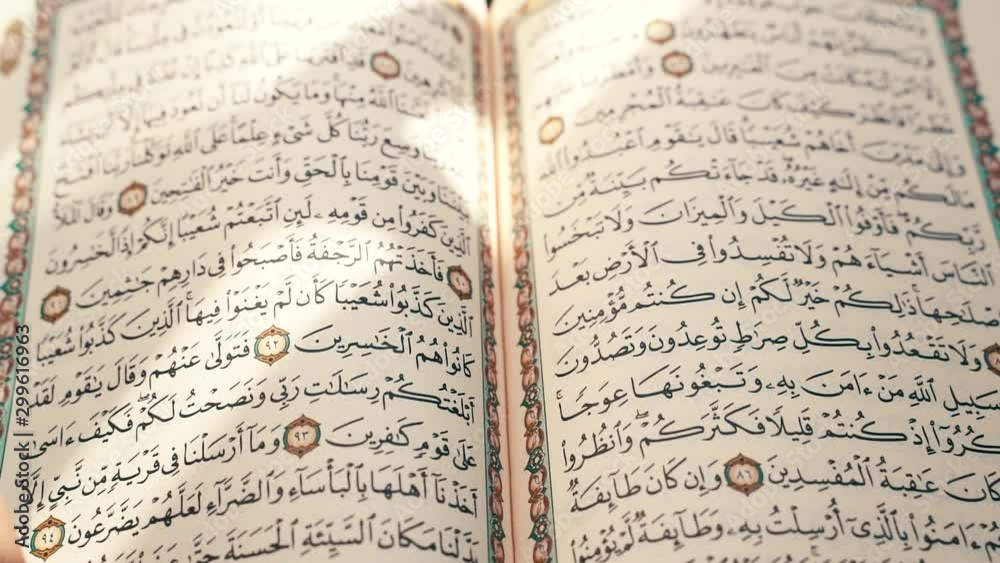 hand flipping the pages of the holy Quran muslim holy book, detail of ...