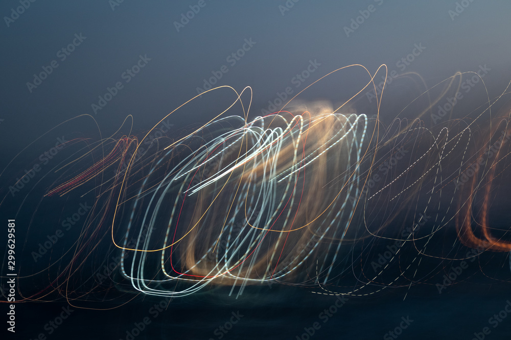 Abstract swirls and waves of light against the night sky. Drawing light ...