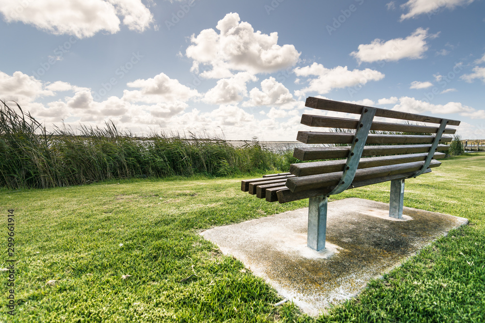 Lakeside Park Bench with a view. Blue sky with puffy white clouds ...