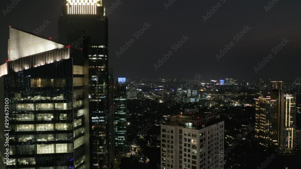 Illuminated night cityscape skyline aerial view across futuristic ...