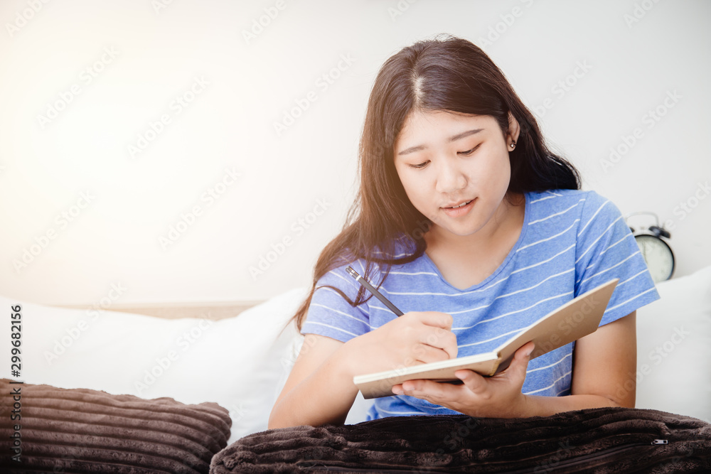 Girl teen taking short note writing to do list at bed when her wakeup ...