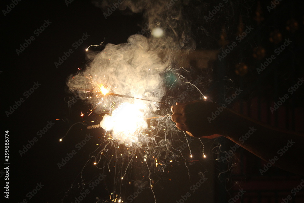 human Hand holding the sparkler on sparkling with dark background with ...