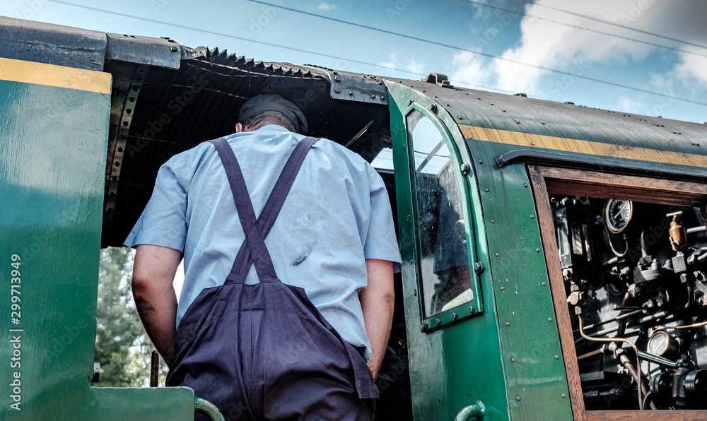 Steam locomotive driver seen within his control room at the front of ...