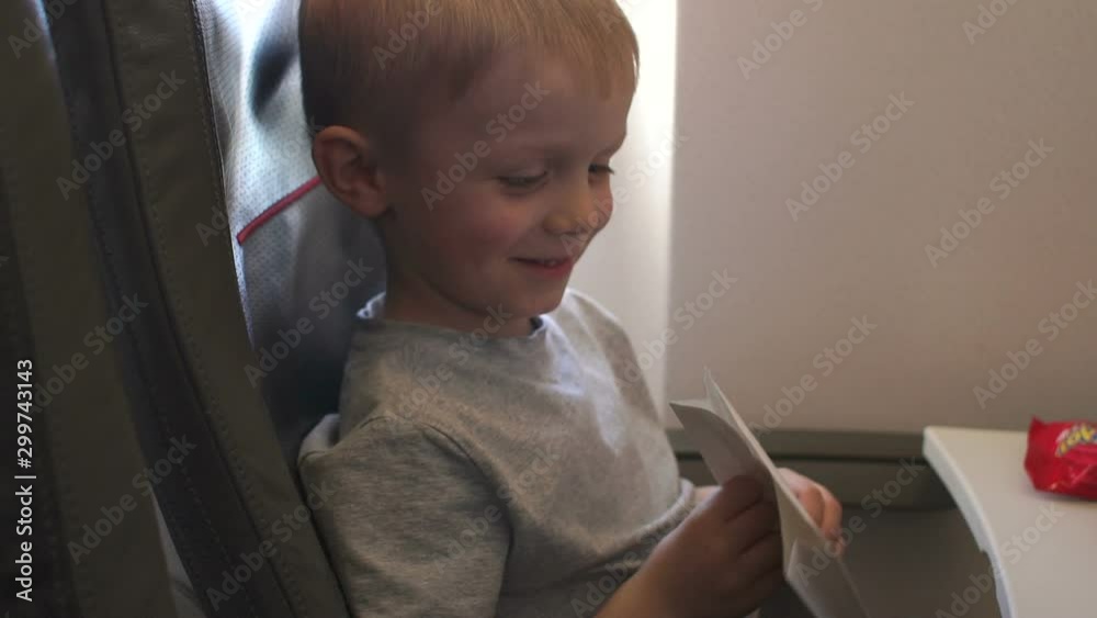 Close-up portrait of a little boy on a plane, he is vomits and he is ...