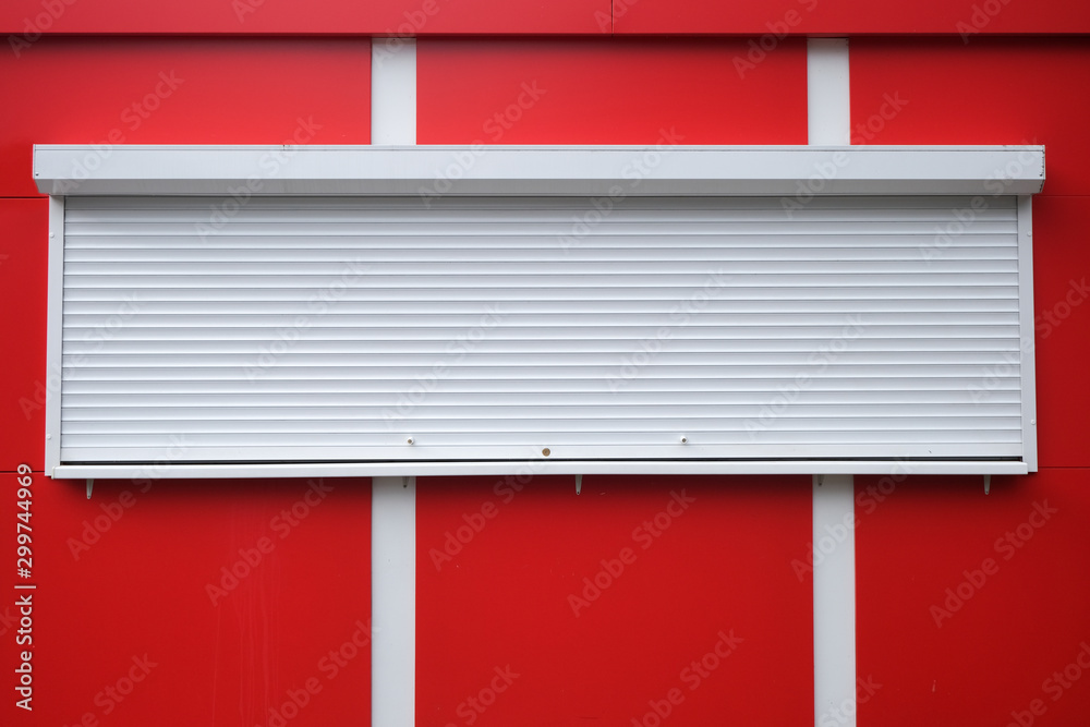 White roller shutters at a red kiosk. Street retail, shop, market ...