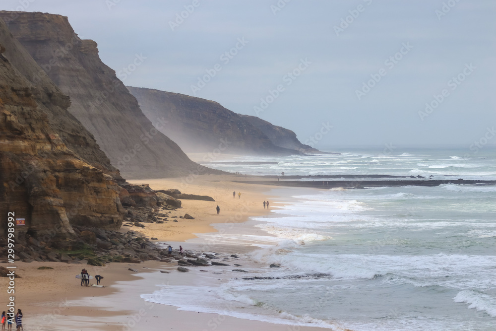 Beach with a big cliff in background in a winter day Portugal Stock ...