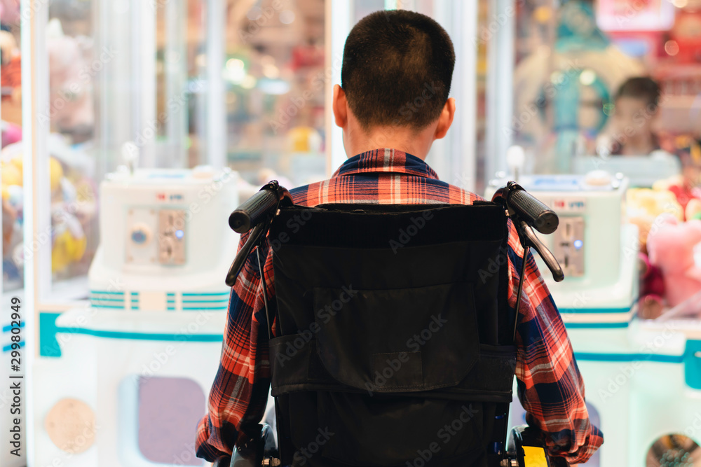Disabled child on wheelchair having fun have fun playing the dollhouse ...