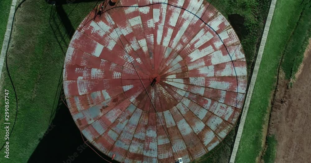 Aerial top view of old rusty grain bin or silo. Circular grey and red ...