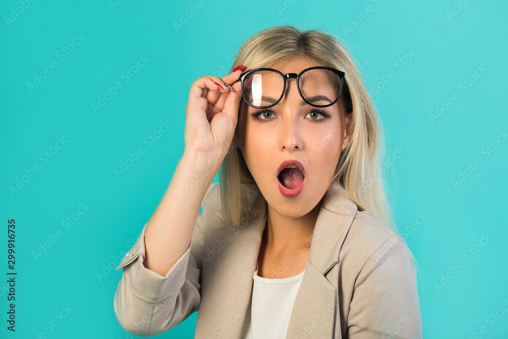 beautiful young woman in a suit on a blue background with a surprised ...